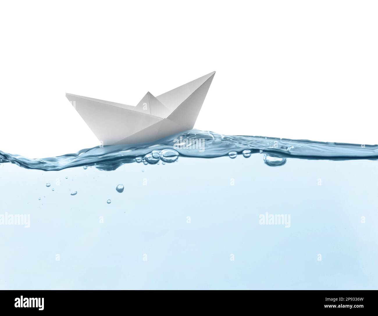 Handmade paper boat floating on clear water against white background ...