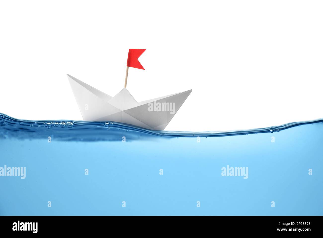 Handmade paper boat floating on clear water against white background ...