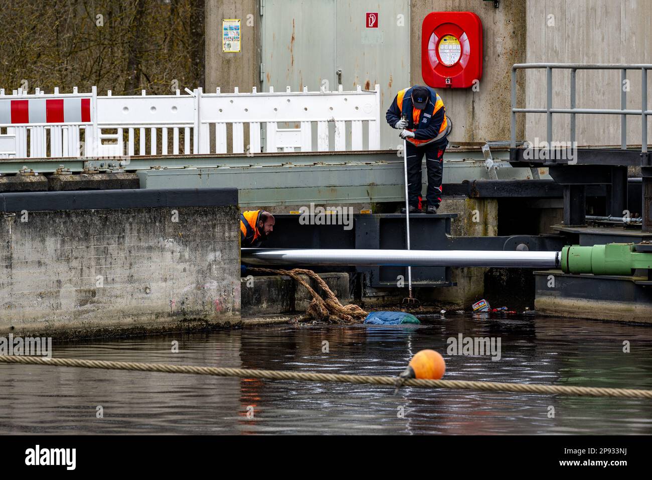 10 March 2023, Bavaria, Wörth an der Donau: A man is removing flotsam ...