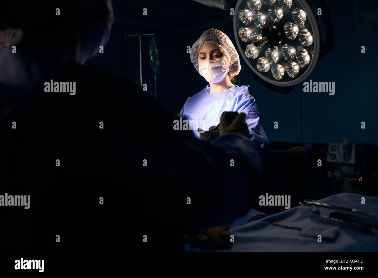 Woman in a surgical uniform stands at the operating table Stock Photo ...