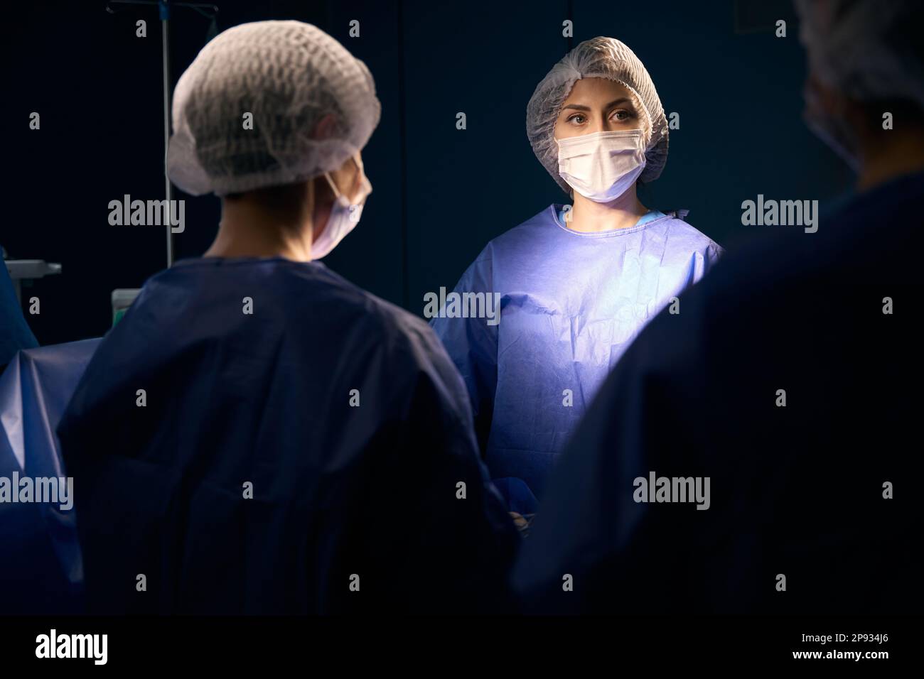 Group of women in surgical uniforms stand at operating table Stock ...