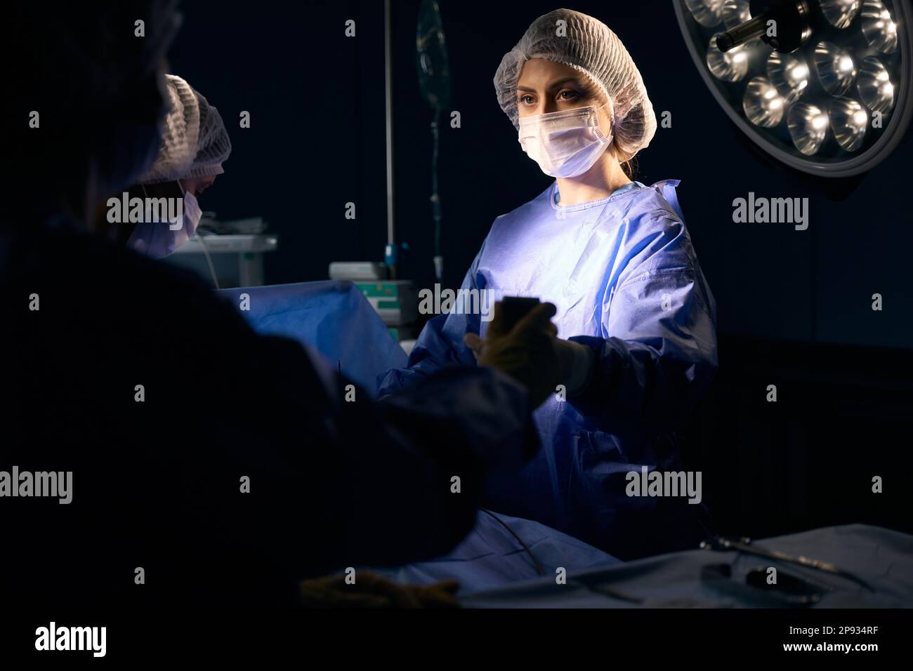 Female stands at the surgical table in the operating room Stock Photo ...