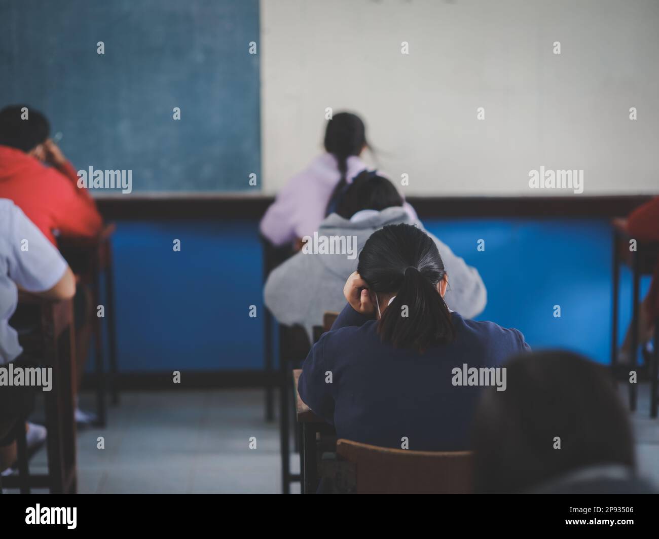 Students reading exam answer sheets exercises in classroom of school ...
