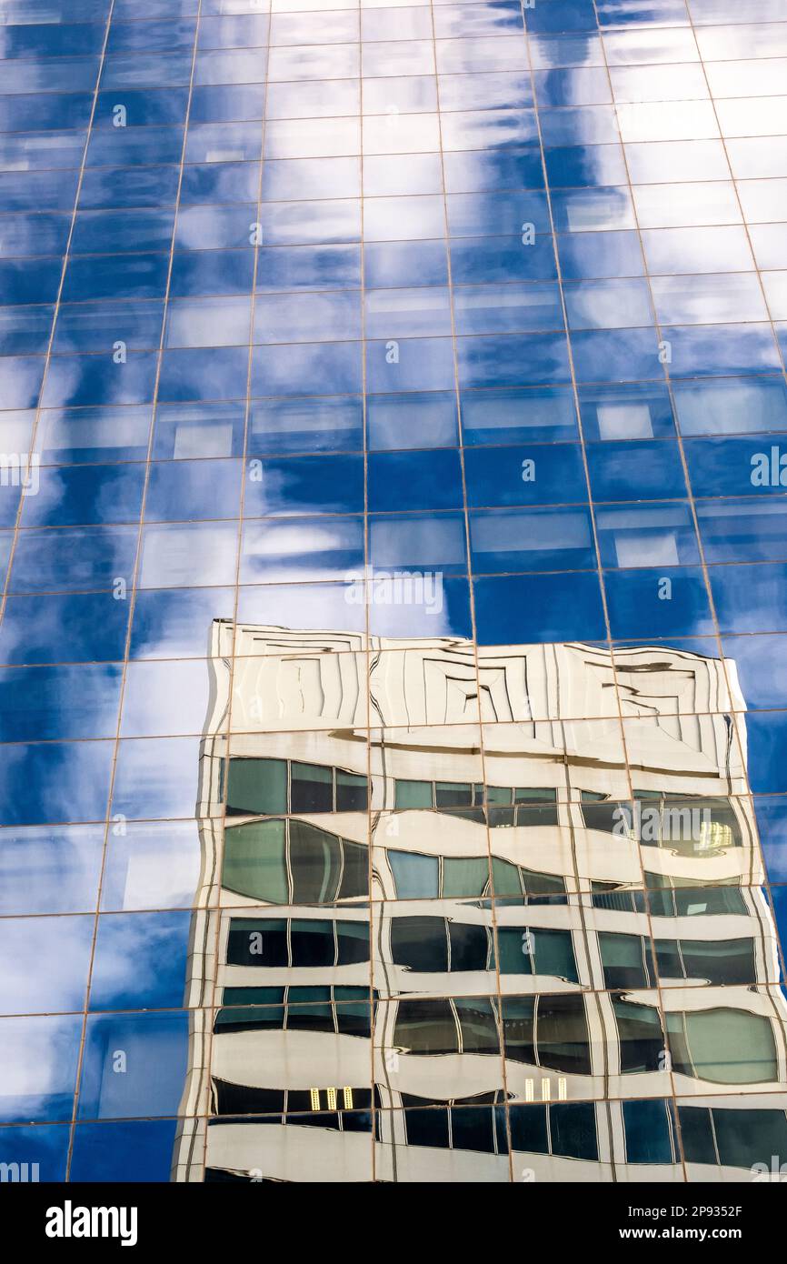 Buildings reflected in the glasses of the facade of a modern building ...