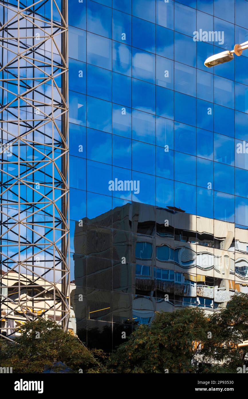 Buildings reflected in the glasses of the facade of a modern building ...