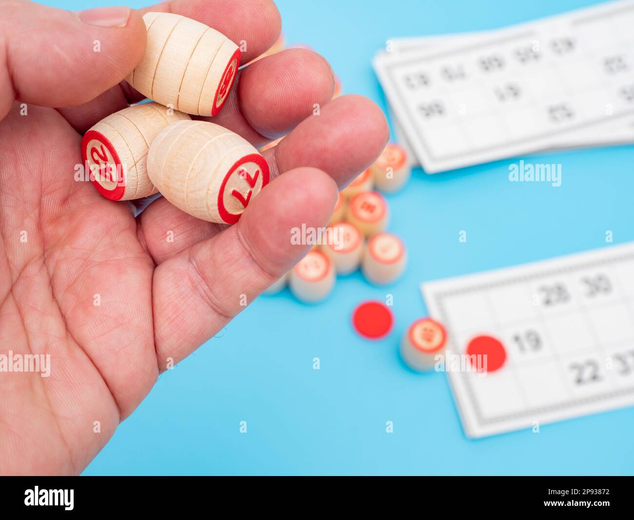 Board game bingo. Wooden barrels with numbers in hand. Close-up Stock ...