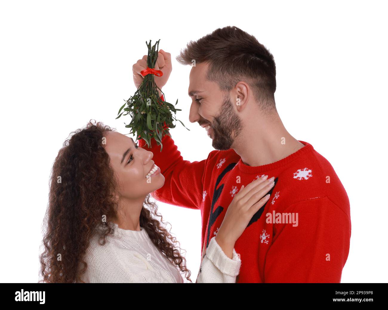 Lovely couple under mistletoe bunch on white background Stock Photo - Alamy
