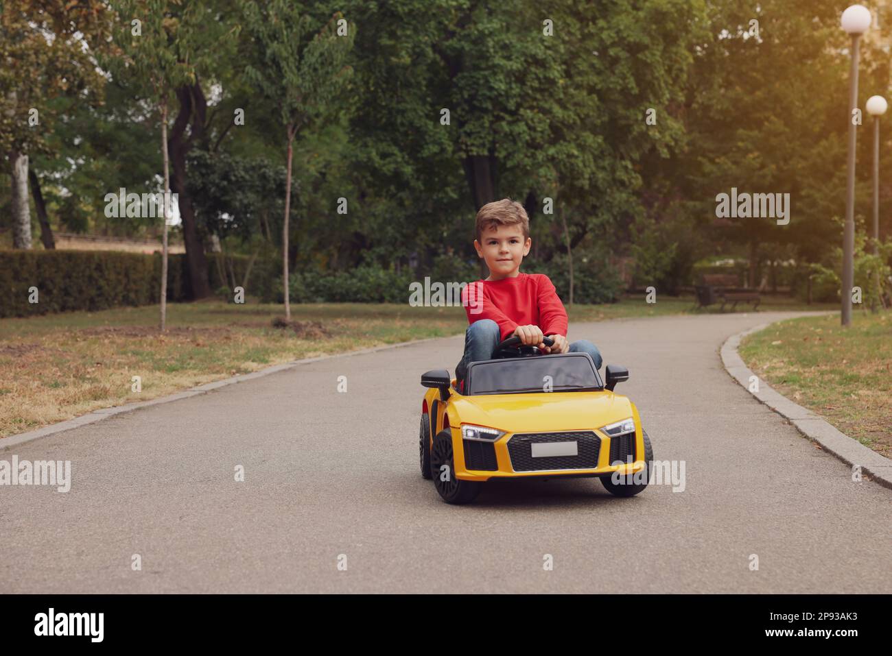 Cute little boy driving children's car outdoors. Space for text Stock ...