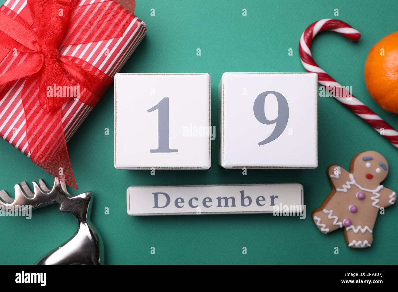 Wooden block calendar with date 19th of December, gift box, treats and ...