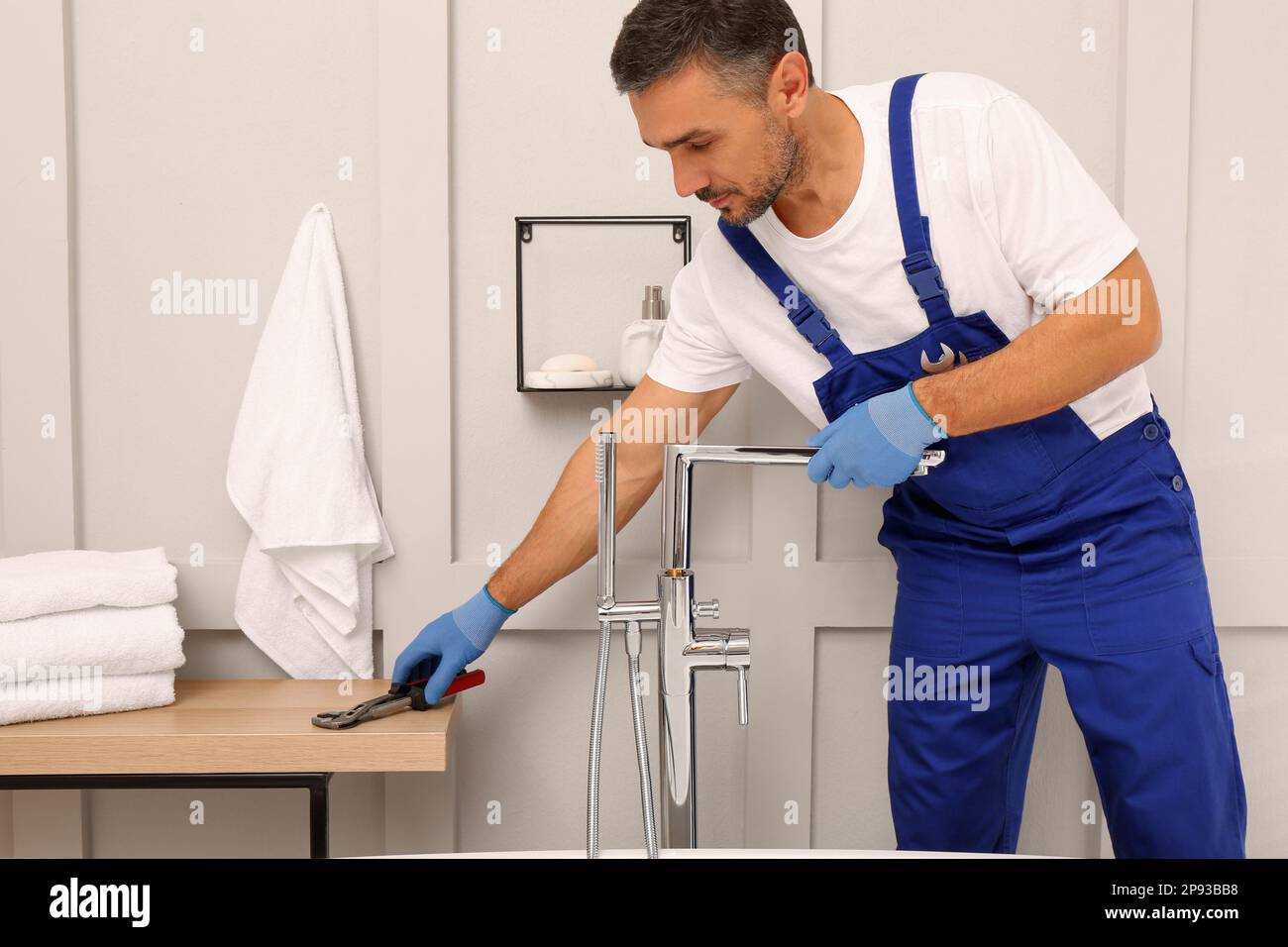 Professional plumber installing water tap in bathroom Stock Photo - Alamy