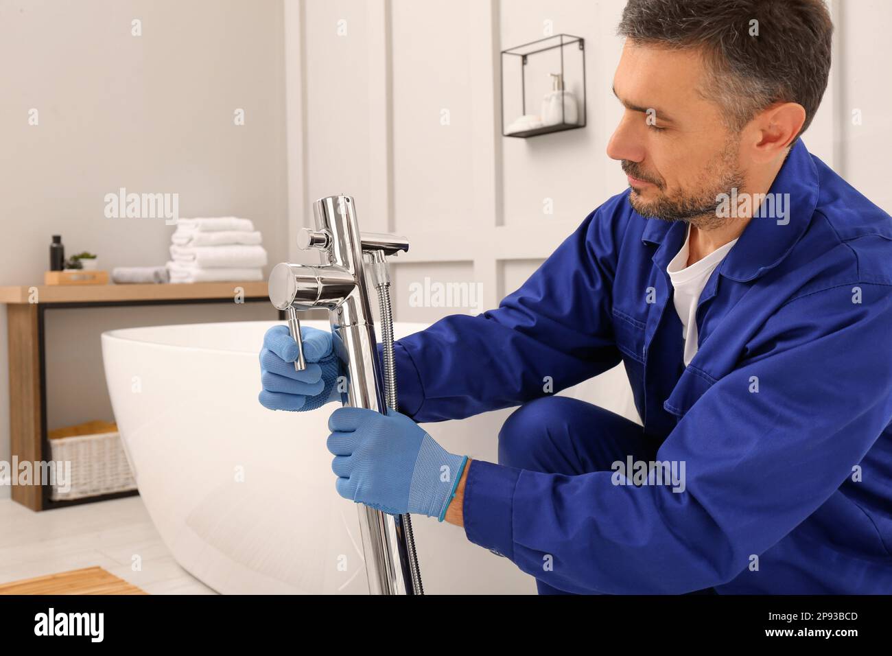 Professional plumber installing water tap in bathroom Stock Photo - Alamy