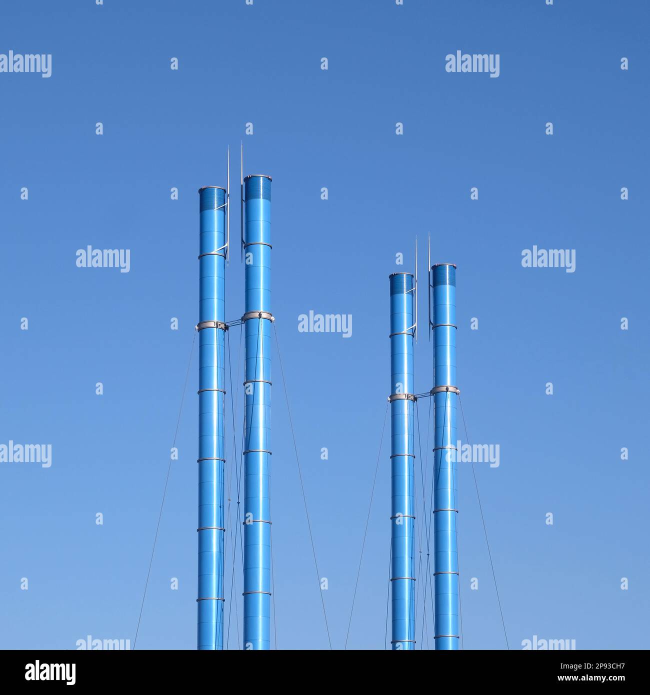 Four painted blue smoke stacks on clear blue sky with no clouds Stock ...