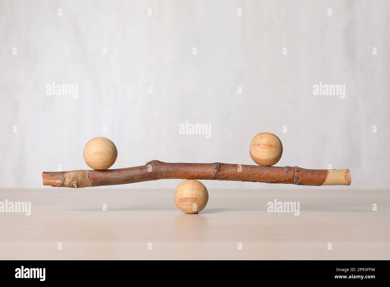 Tree branch with wooden balls on table, space for text. Harmony and ...
