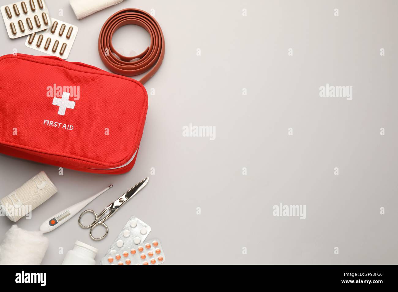 Flat lay composition with first aid kit on light grey background, space ...