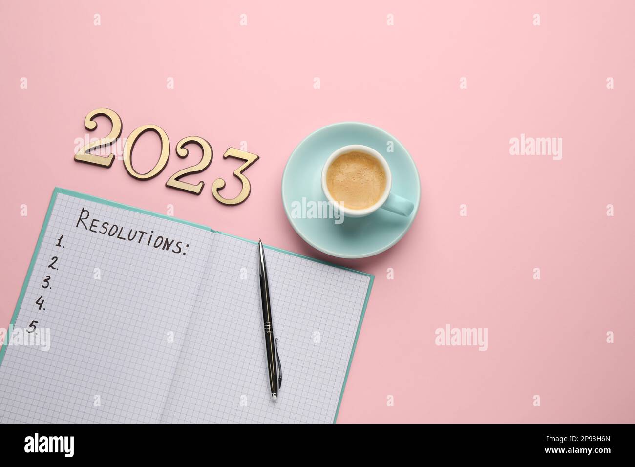 Making resolutions for 2023 New Year. Flat lay composition with notebook on pink background ...
