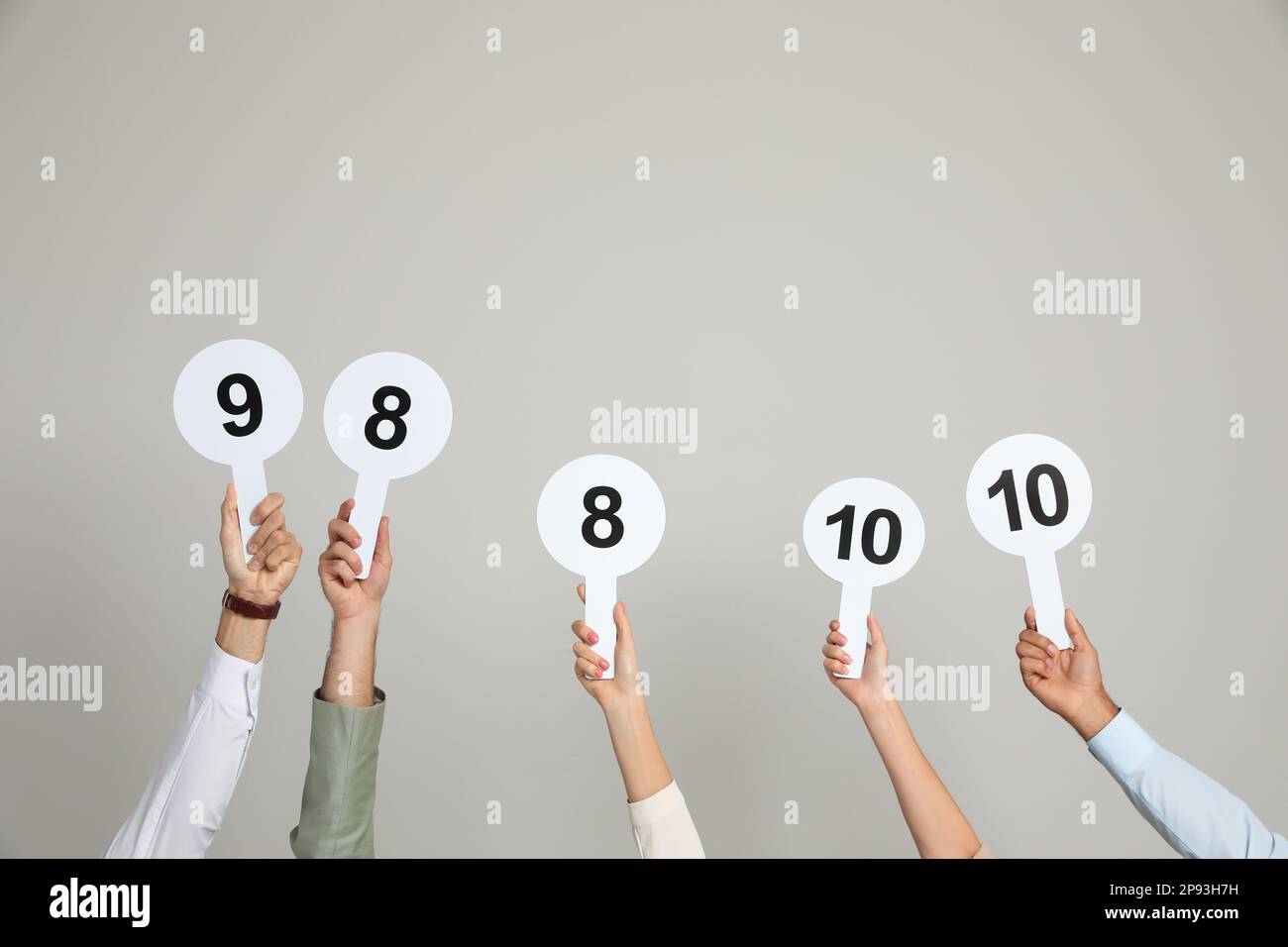 Panel of judges holding different score signs on beige background ...