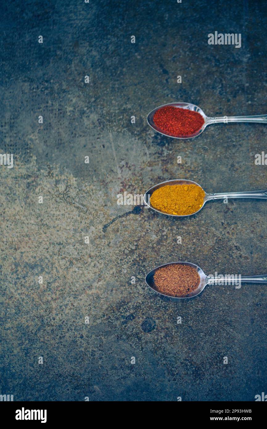 Three teaspoons with the ground spices chili, turmeric and cumin Stock ...