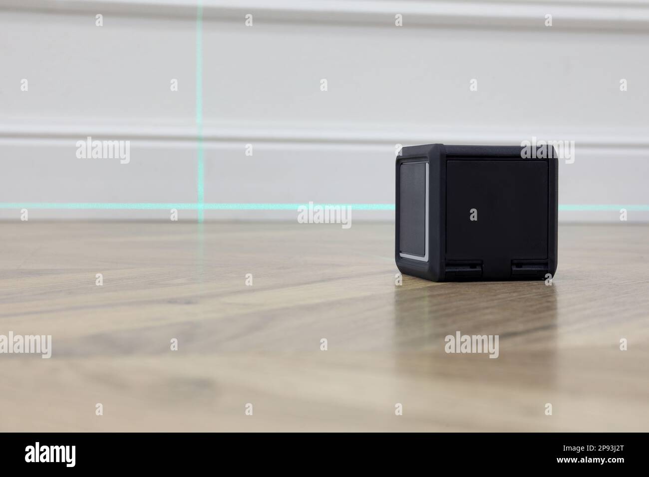Cross line laser level on floor in front of white wall Stock Photo - Alamy