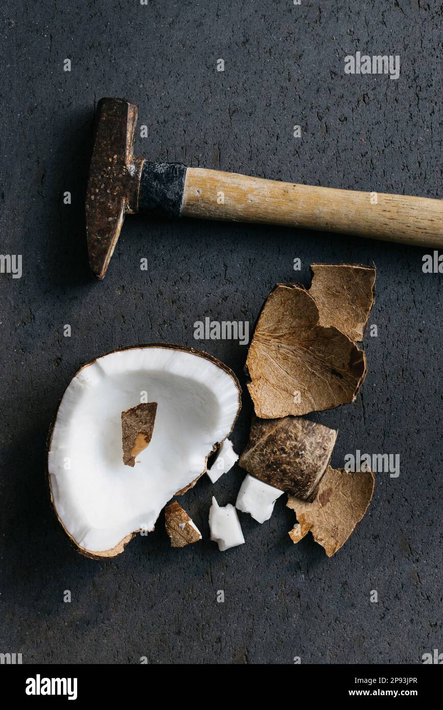 Still life of a hammer next to a cracked coconut Stock Photo - Alamy