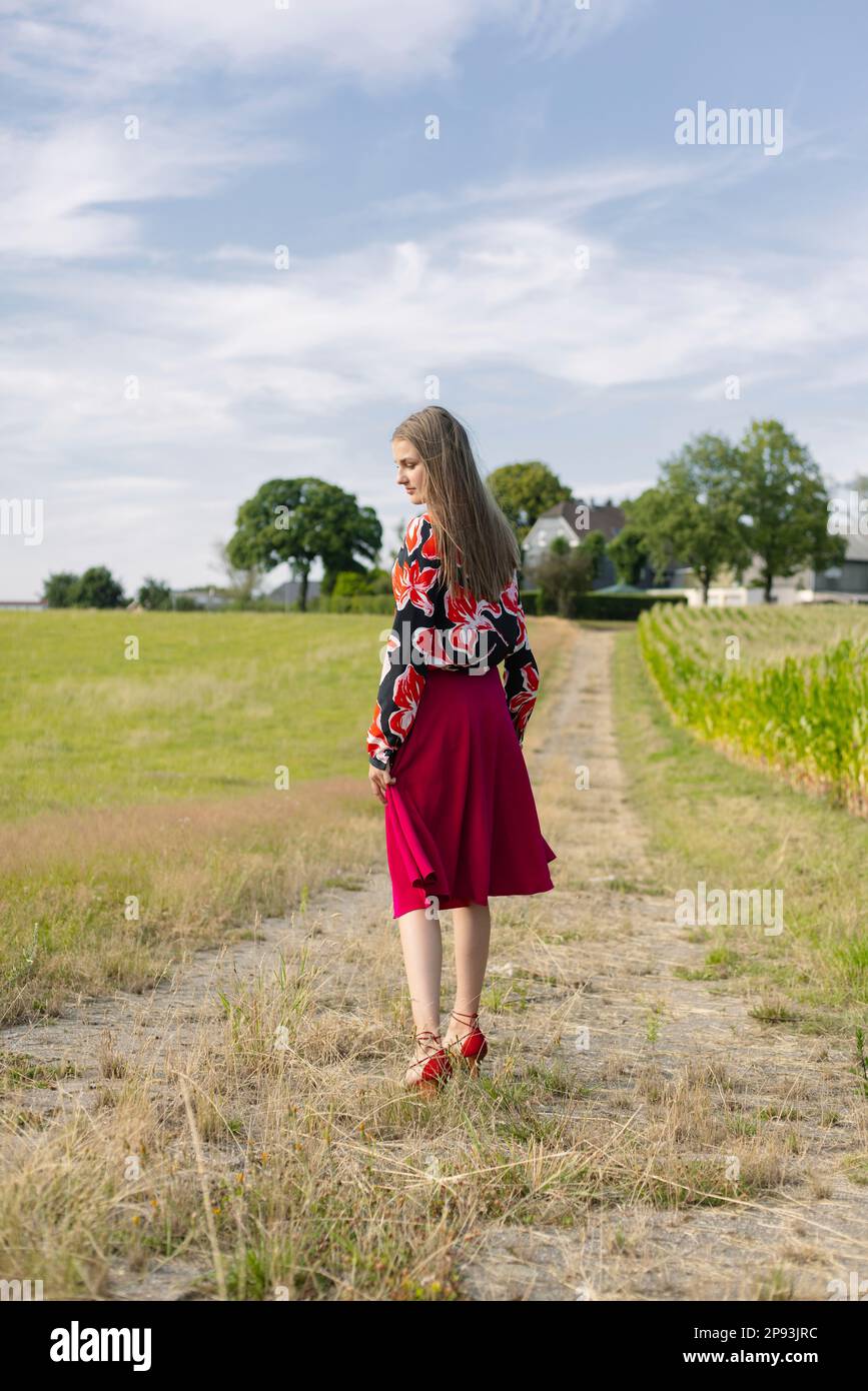 Girl walking across a meadow to a house in rural area Stock Photo - Alamy
