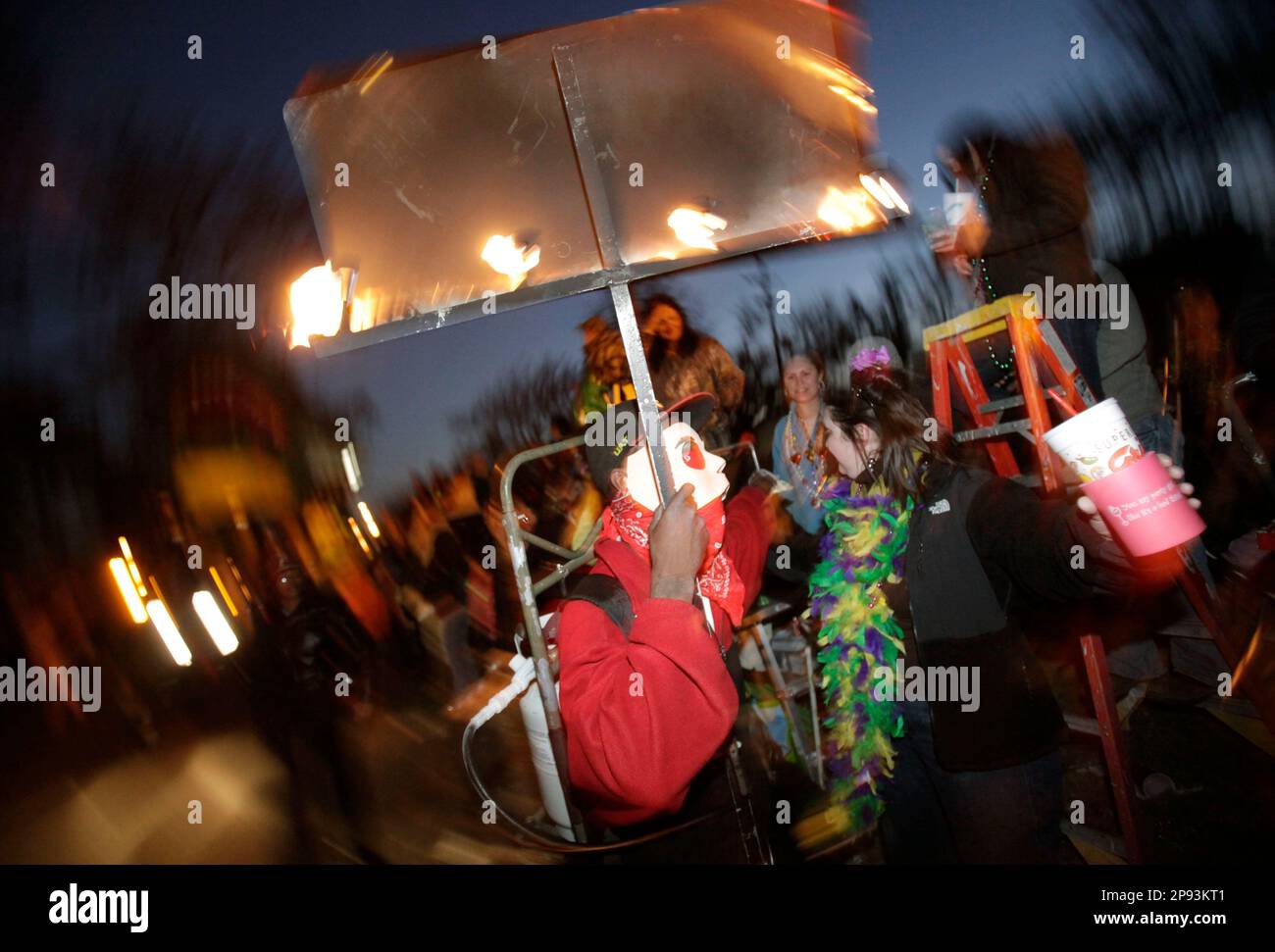 Flambeau carriers light the way during the Krewe of Bacchus parade in ...