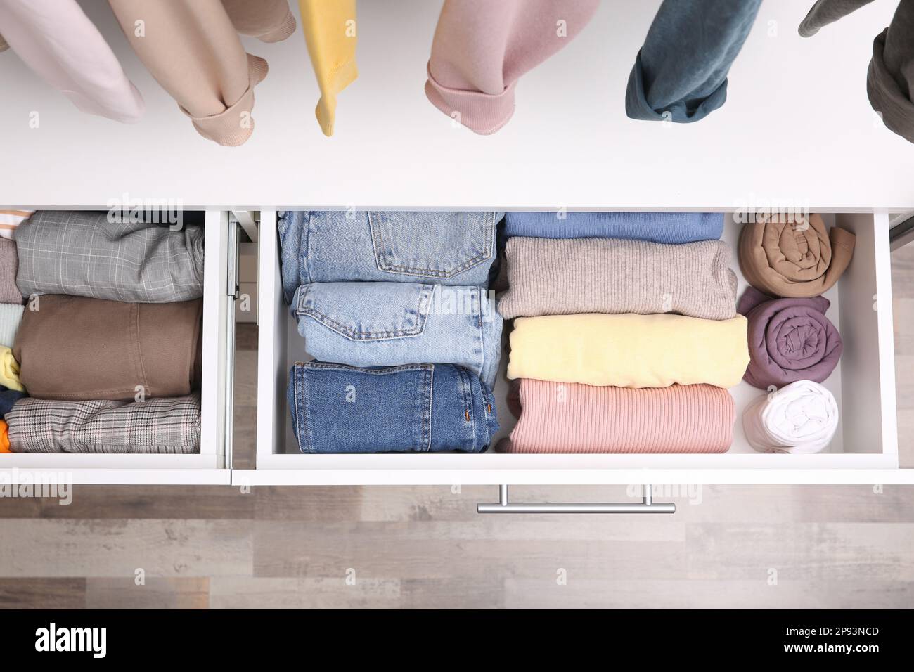 Open drawers with folded clothes indoors, top view. Vertical storage ...