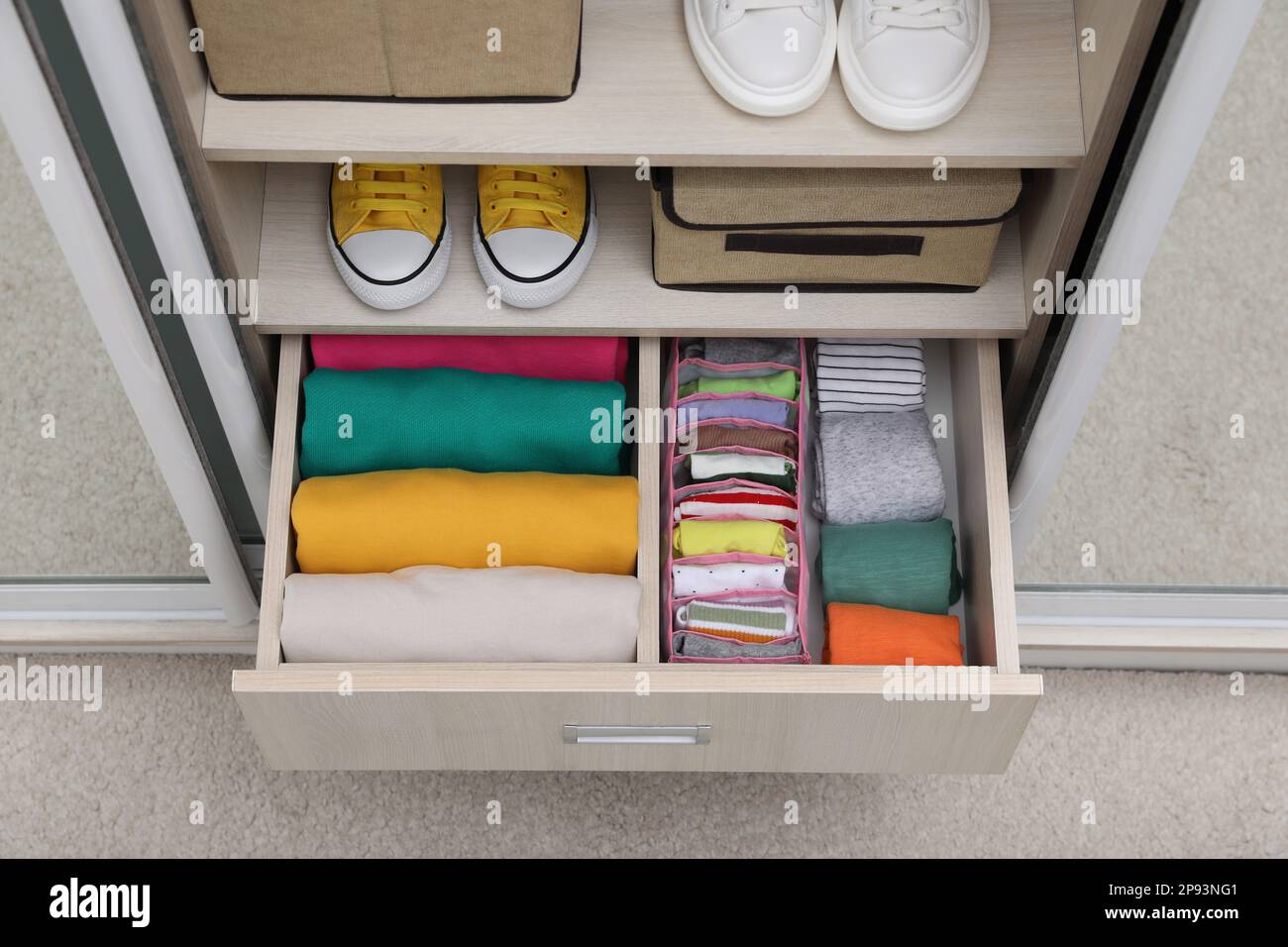 Wardrobe with organized clothes and shoes indoors, above view. Vertical ...