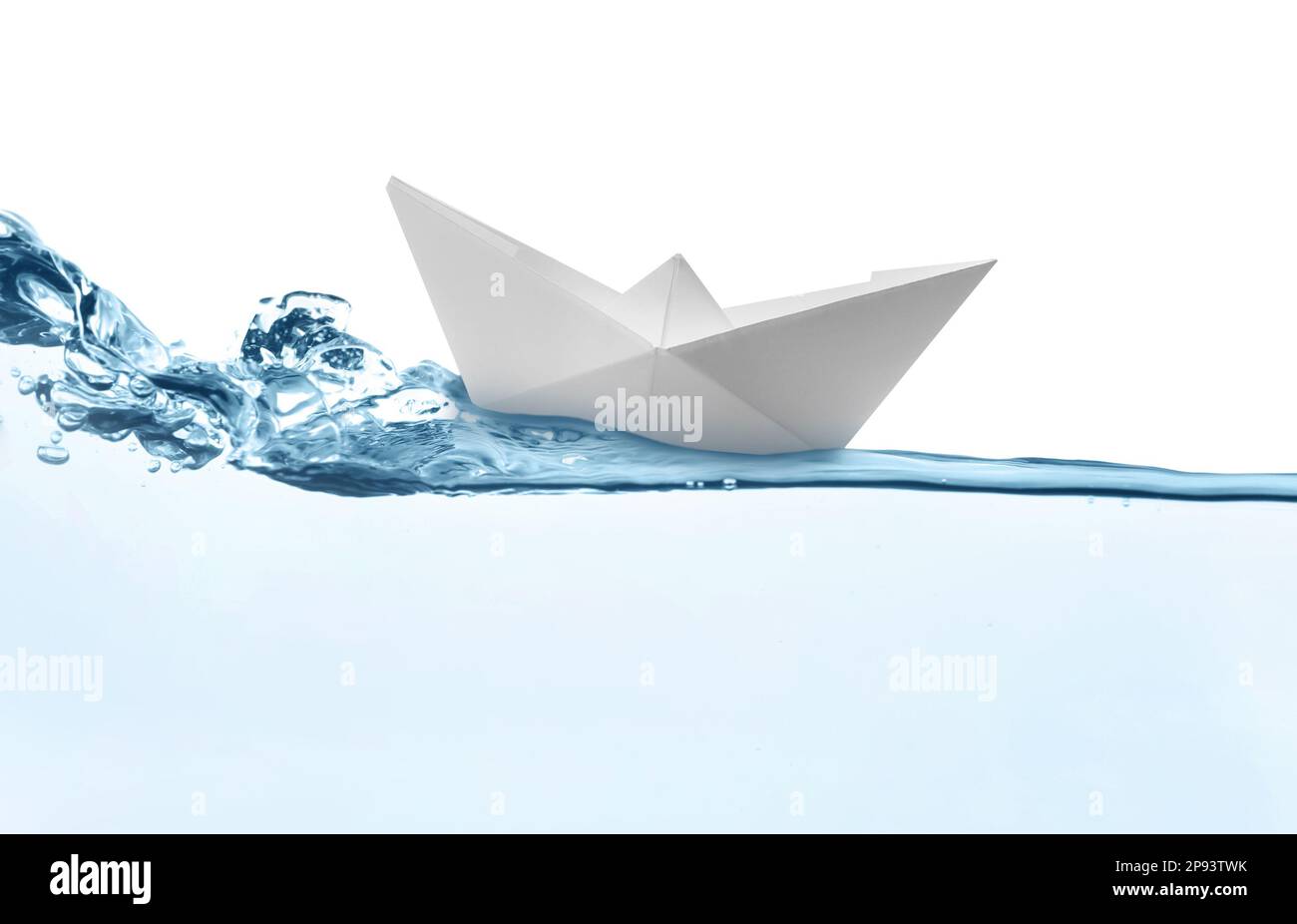 Handmade paper boat floating on clear water against white background ...