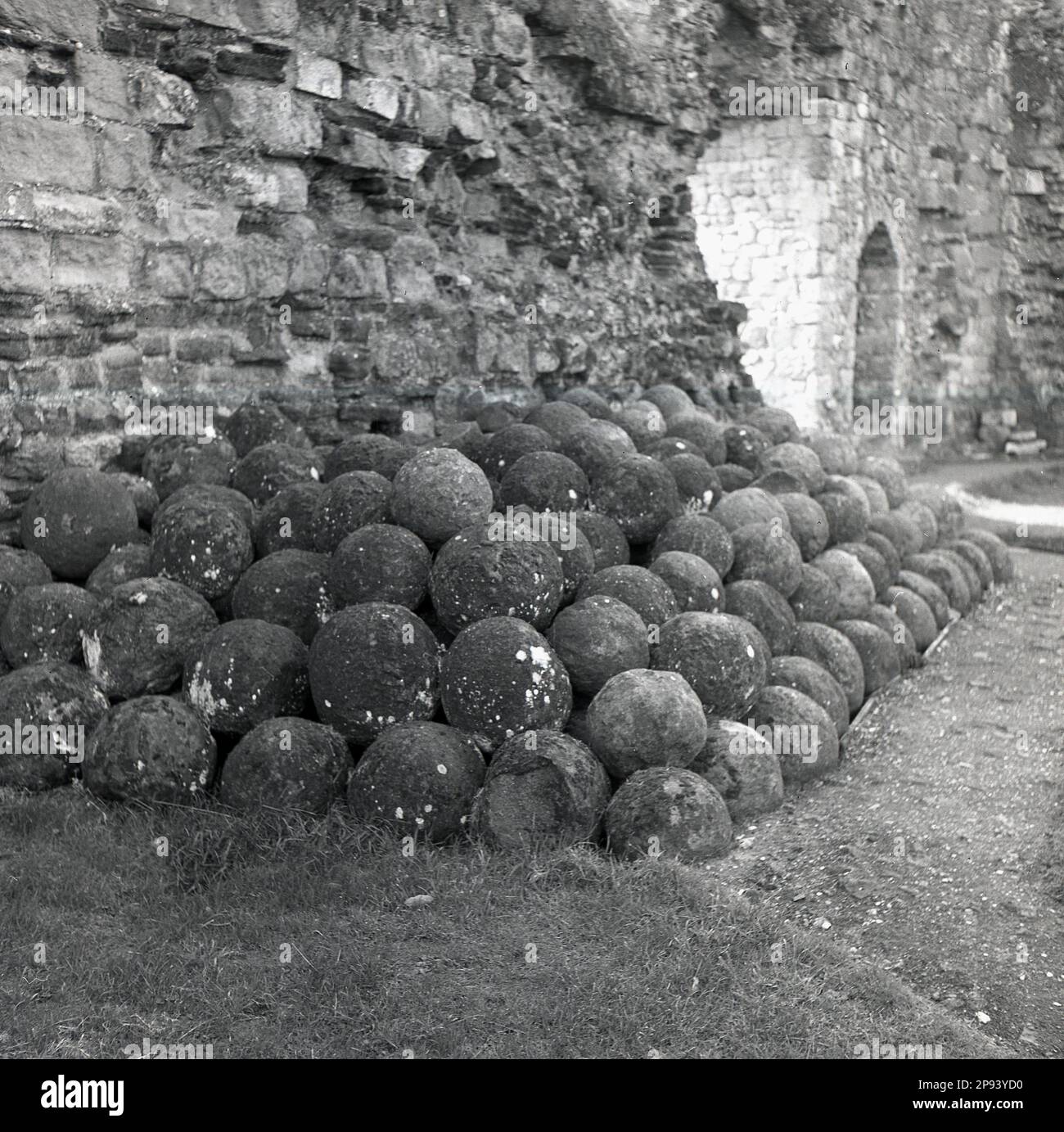 1950s, historical, a pile of ancient cannonballs lying in a stack ...