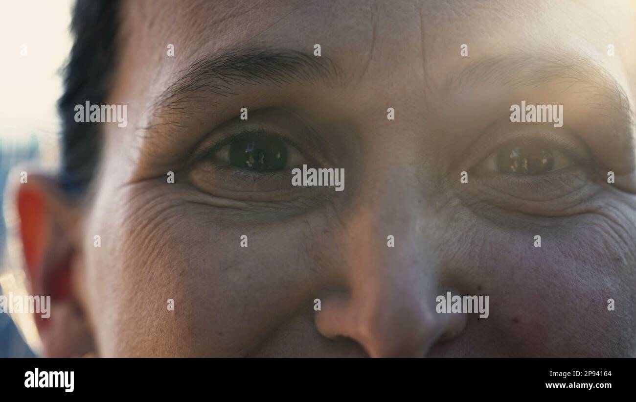 Extreme close up of a woman in her 40s eyes turning head to camera with ...