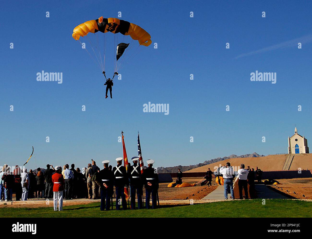A member of a Golden Knights Parachute Team drops down in front of a ...