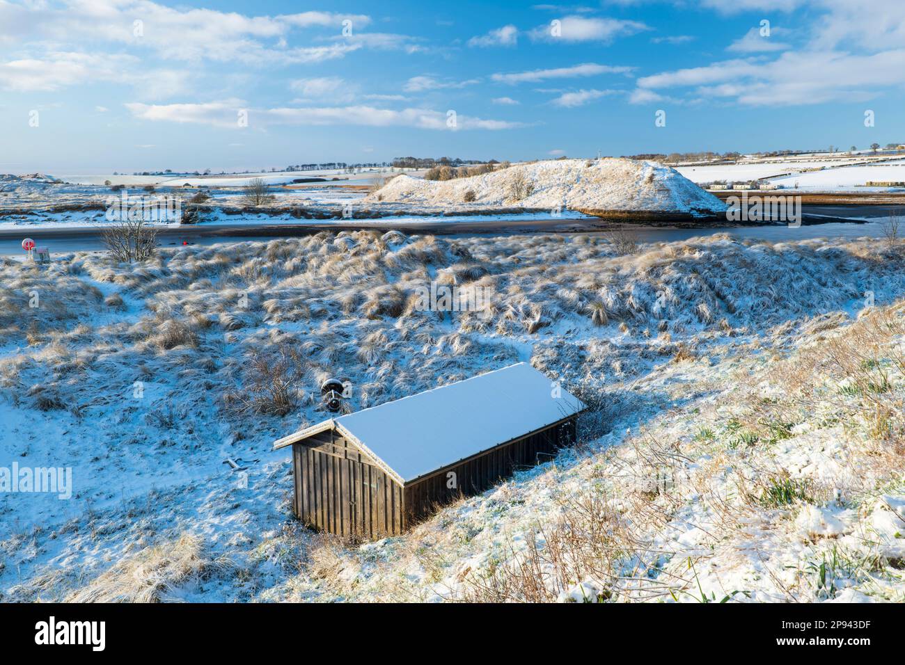 England, Northumberland, Alnmouth. Snow covered sand dunes near the ...