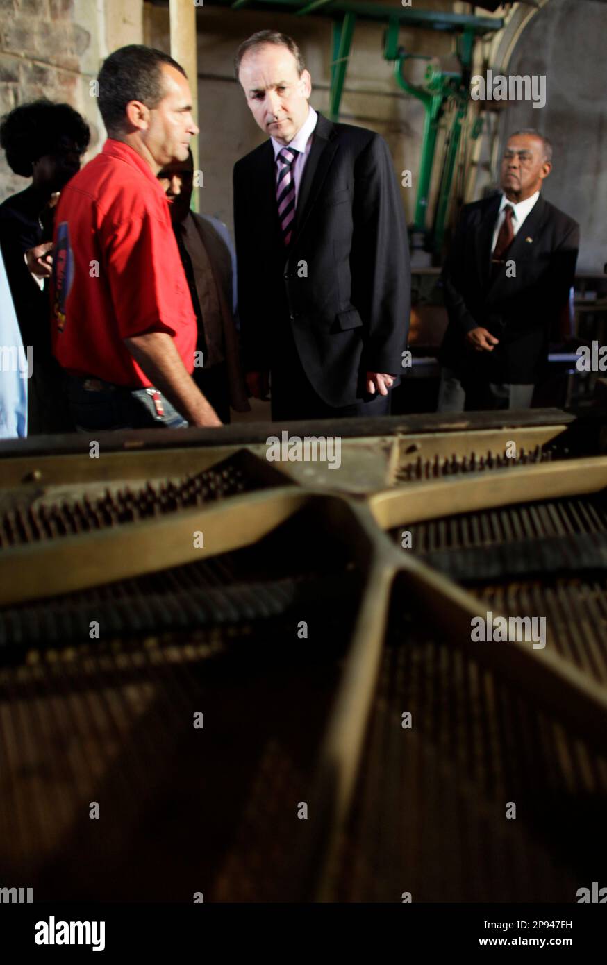 Irish Foreign Minister Michael Martin, center, looks at a piano to be ...
