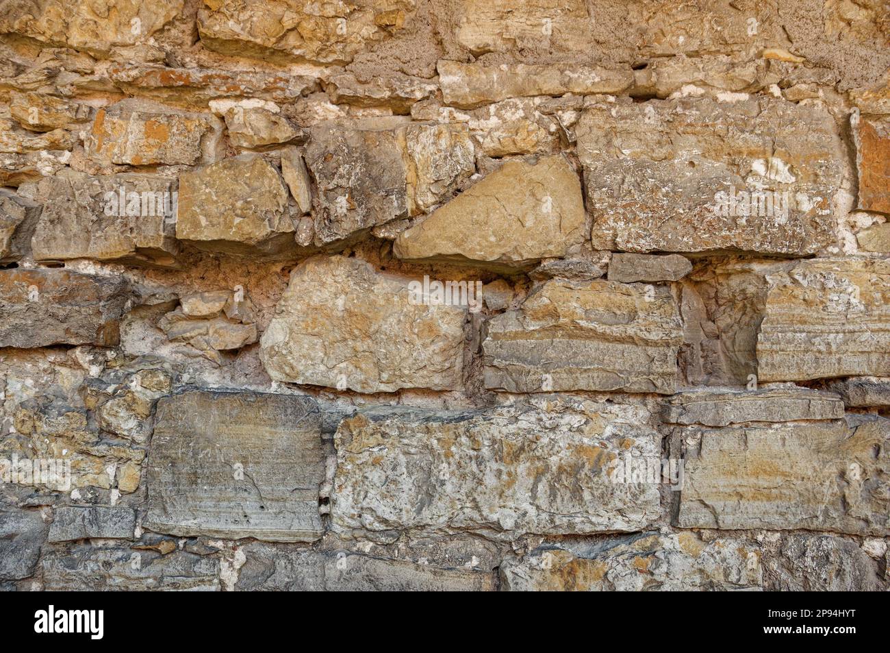 A wall constructed from large stone blocks with several small slabs ...