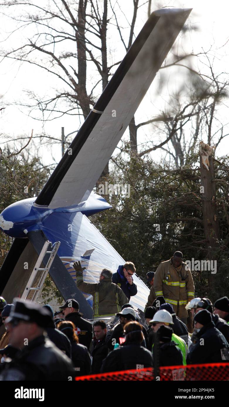 Workers remove debris at the scene of a plane crash site of Continental ...