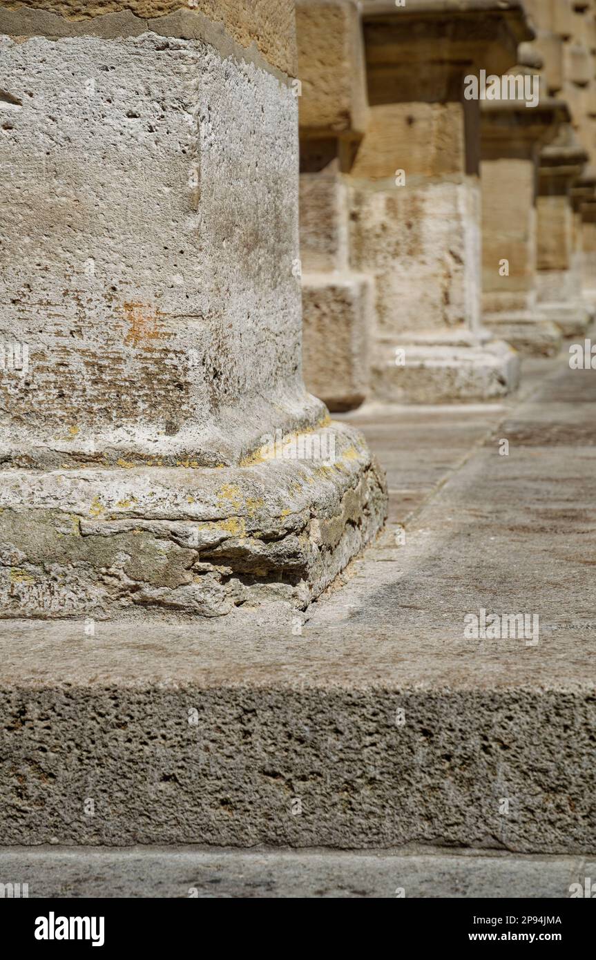 A close-up view of a grey stone pillar set at the base of an aisle in a ...