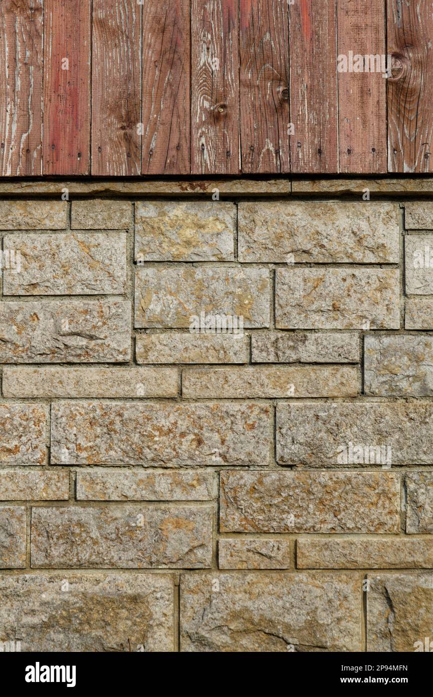 A vertical shot of a building with red wood decks and symmetrical stone ...