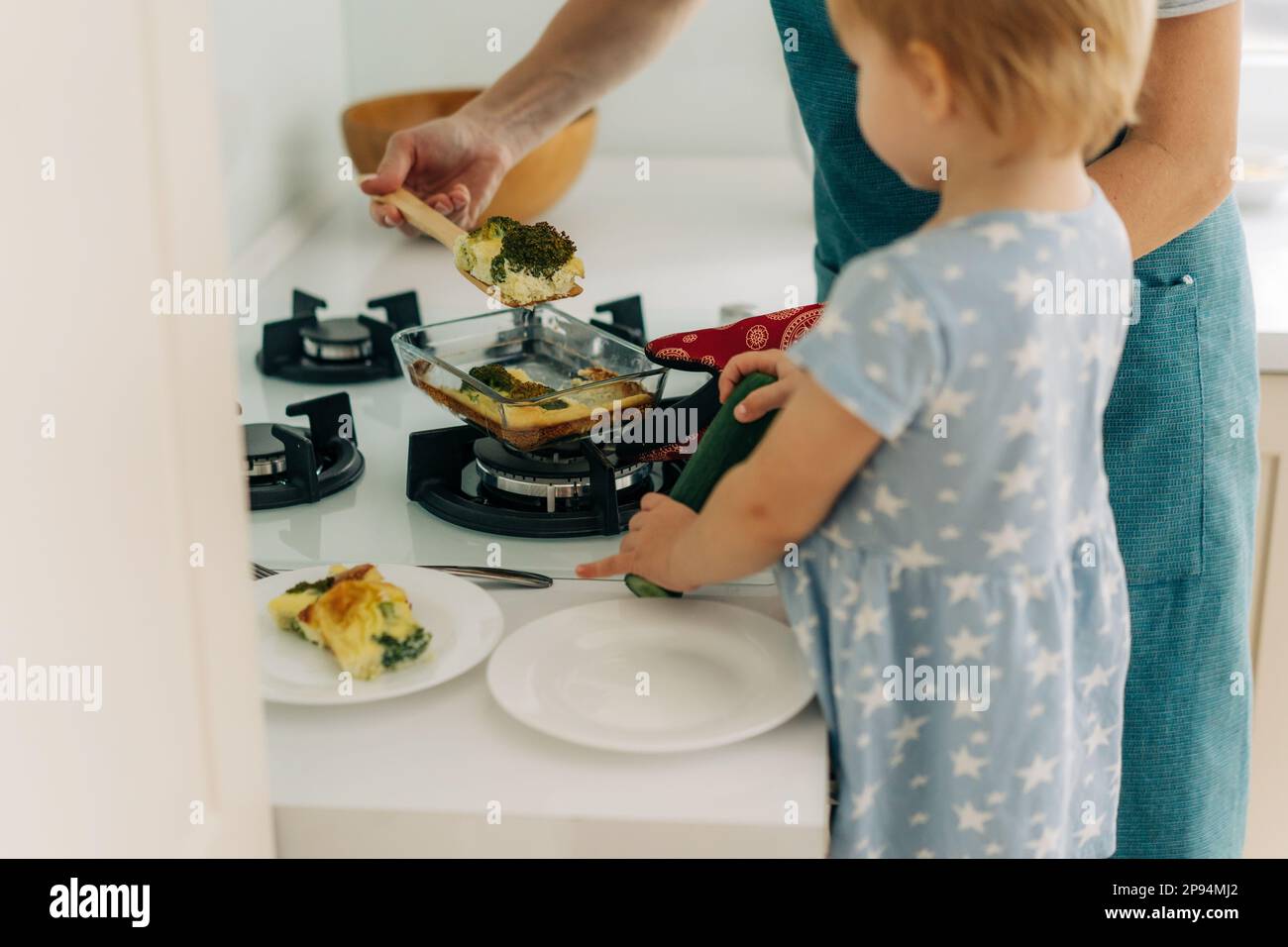 Mom and daughter lay out the dinner on plates Stock Photo - Alamy