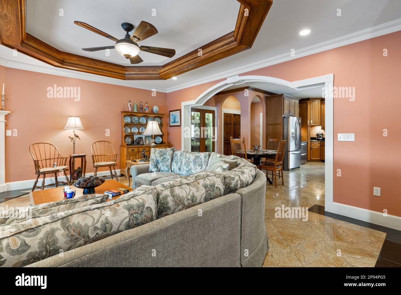 A large living room with a ceiling fan and table and chairs Stock Photo ...
