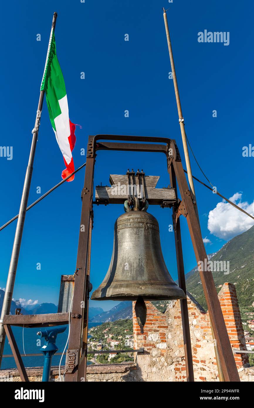 Bell and flag on Scaliger Castle with view of Malcesine and Lake Garda ...