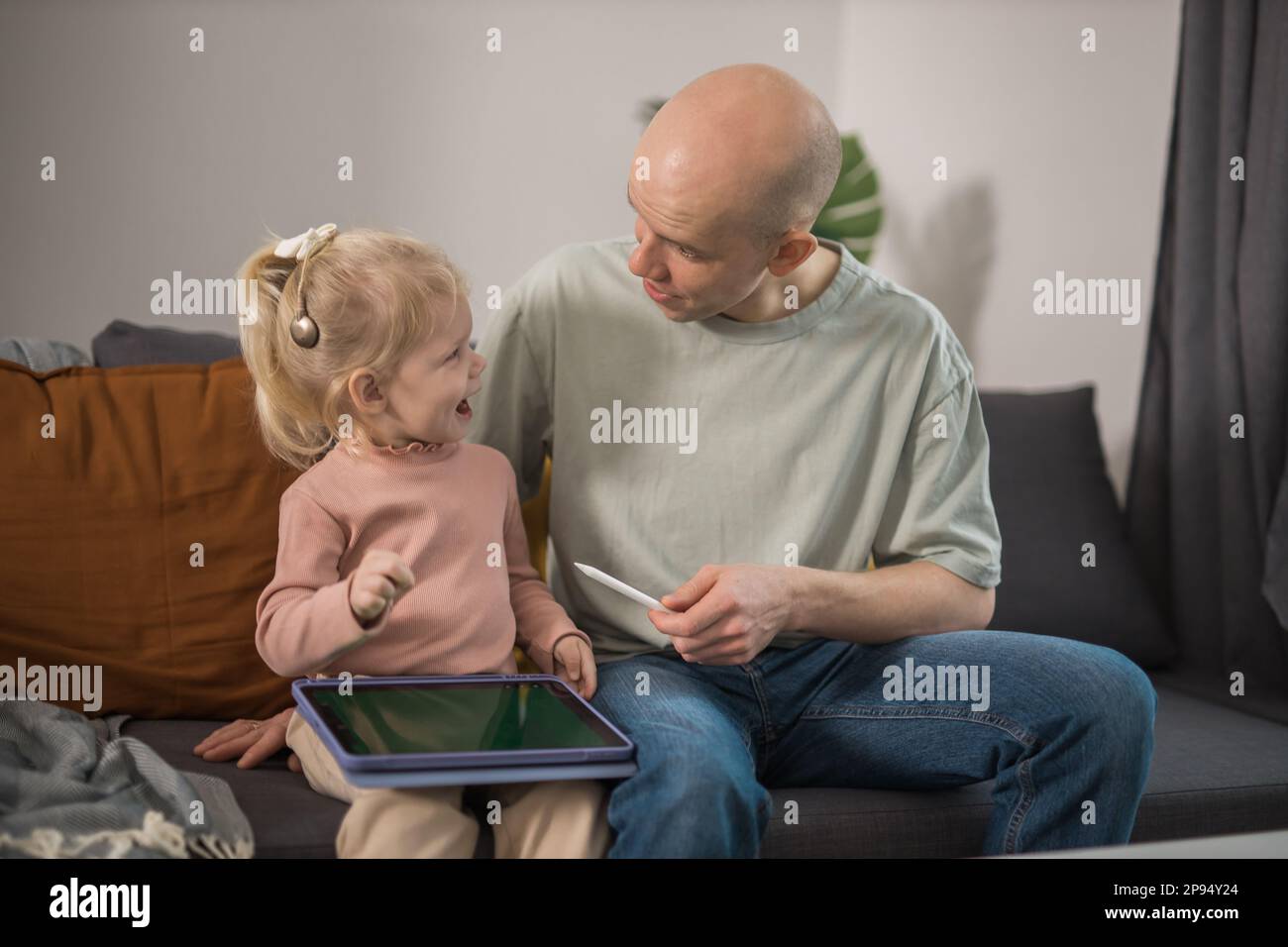 Deaf child girl with cochlear implant studying to hear sounds and have ...