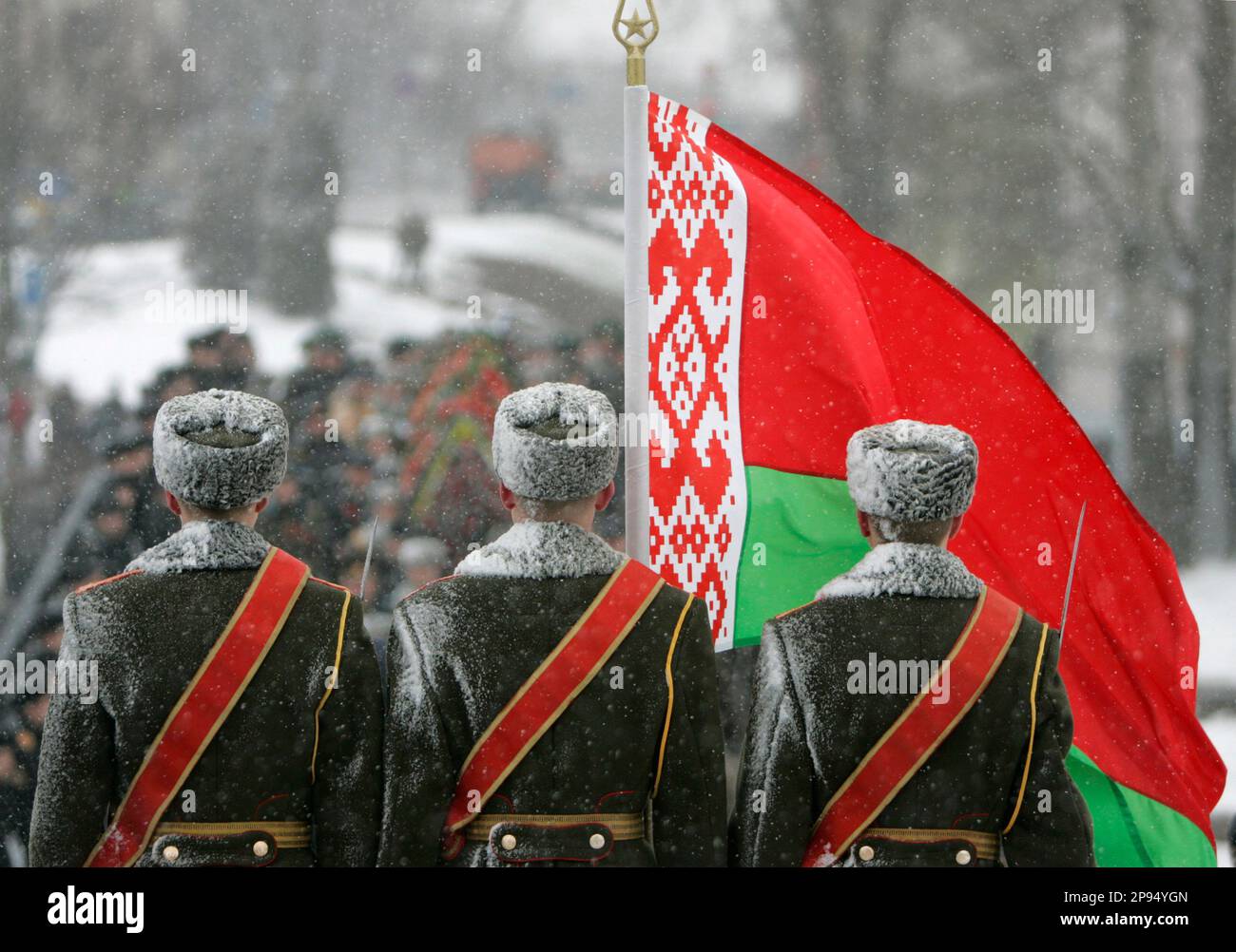 Belarusian soldiers from the honor guard stand with the state flag ...