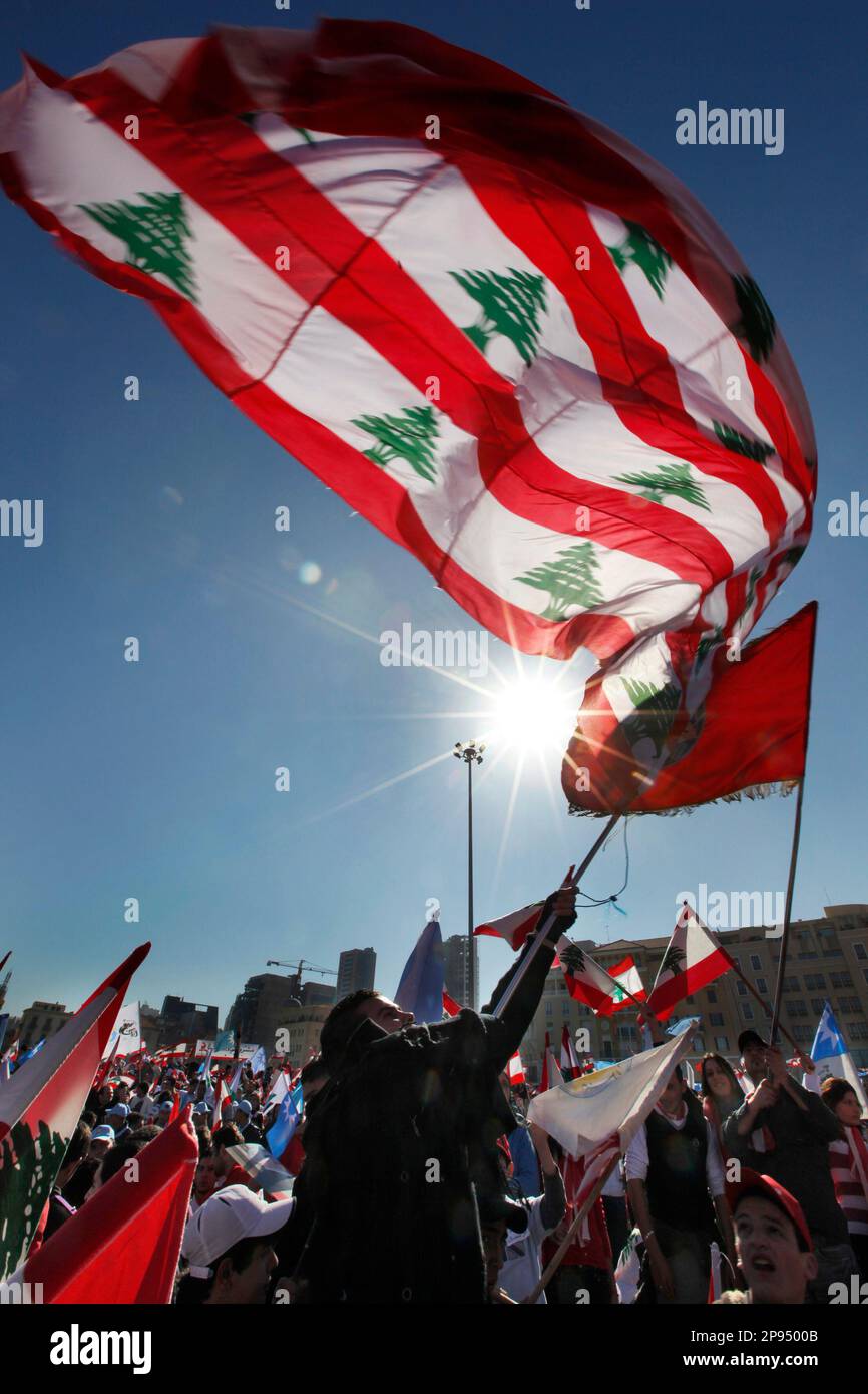 Protesters wave Lebanese flags as they attend a rally at Martyrs ...
