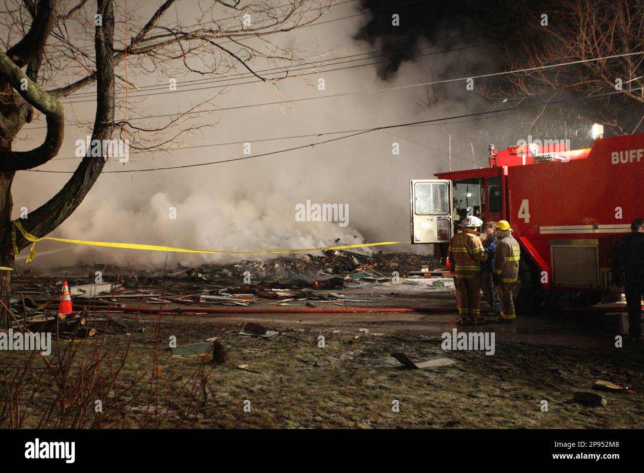 Firefighters observe the site of the crash of Continental Connection ...