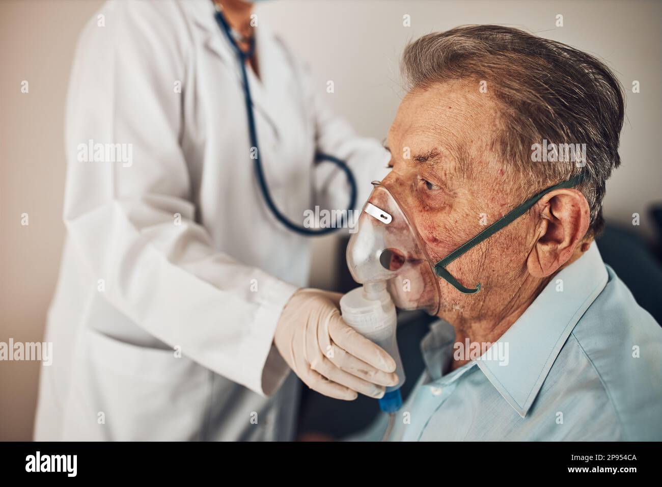 Doctor applying a medicine during inhalation to senior man suffering ...