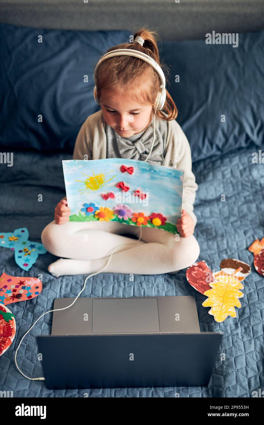 Little girl preschooler learning online showing her works drawings done ...