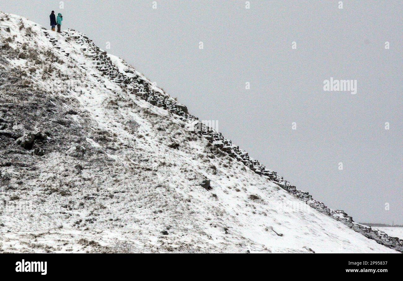 Tourists walk in heavy snow along the historic Hadrian's Wall which ...