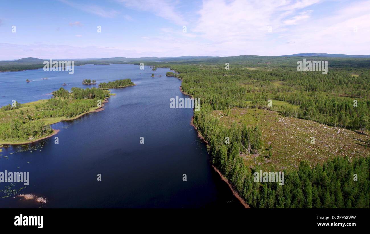 Dark blue water lake surrounded with vast forests and deforestation, in ...