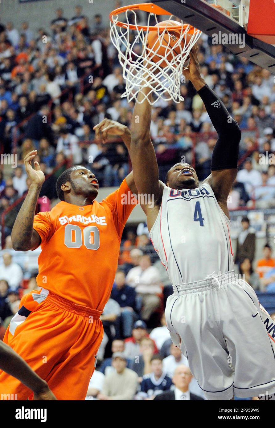 Connecticut's Jeff Adrien, right, scores while being guarded by ...