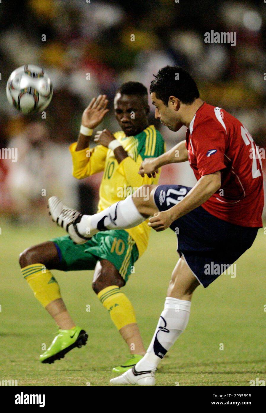 Chile's Rodrigo Tello, right, kicks the ball as South Africa's Teko ...
